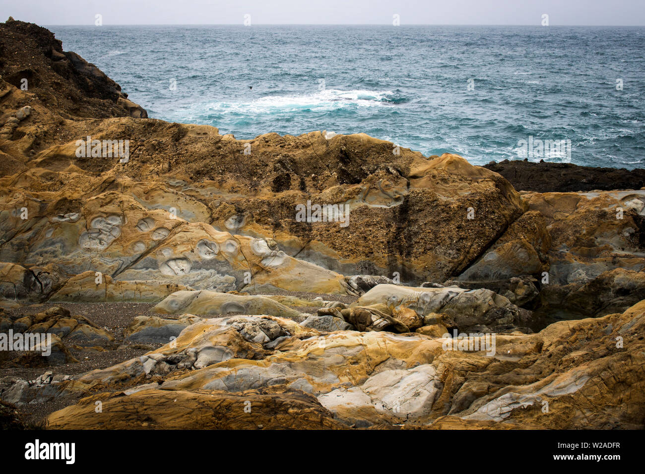 Layers of colorful rock geologic formations on California coast with ...