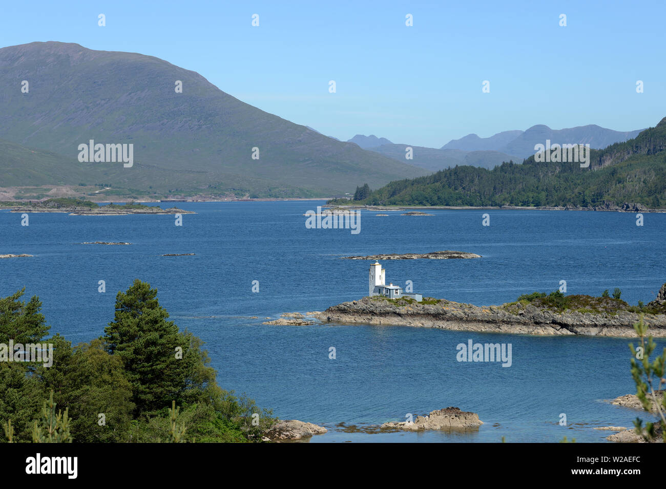 Plockton Lighthouse on the island of Eilean-a-Chait distant mountain ...