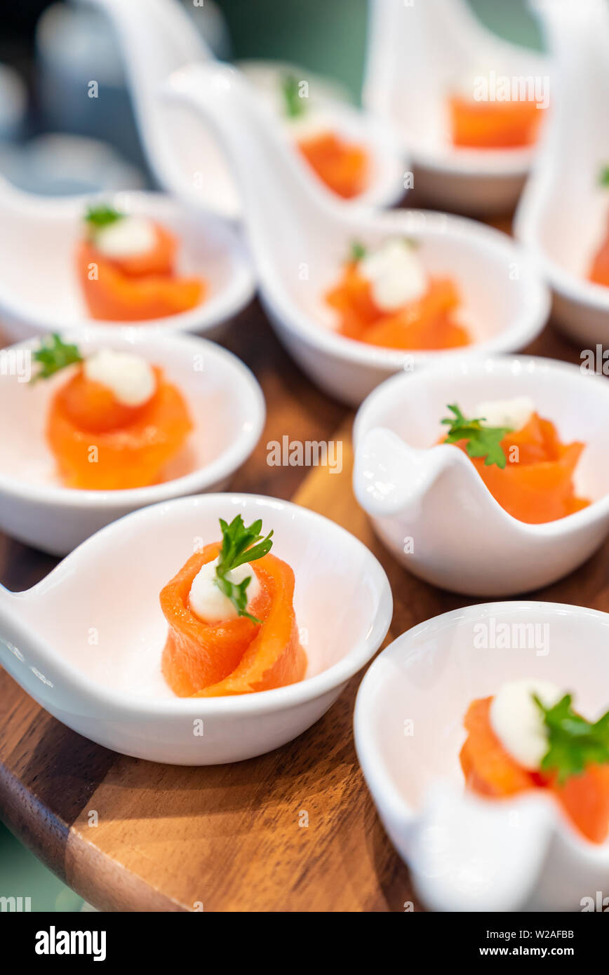 Smoked salmon with cheese tapas served on white spoon as appetizers ...