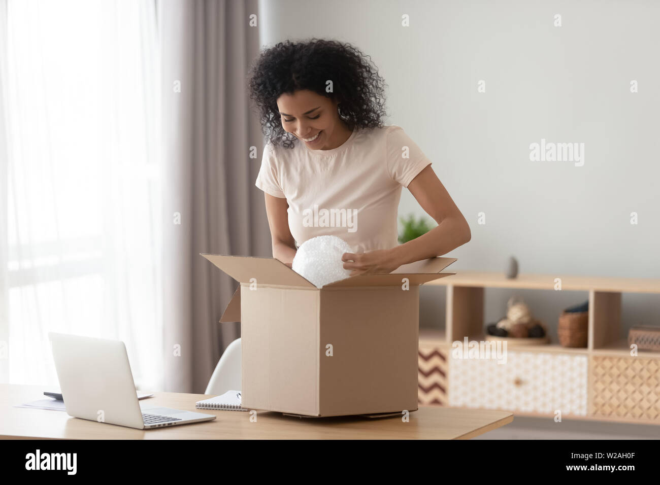 Happy satisfied black girl customer open parcel box at home Stock Photo ...