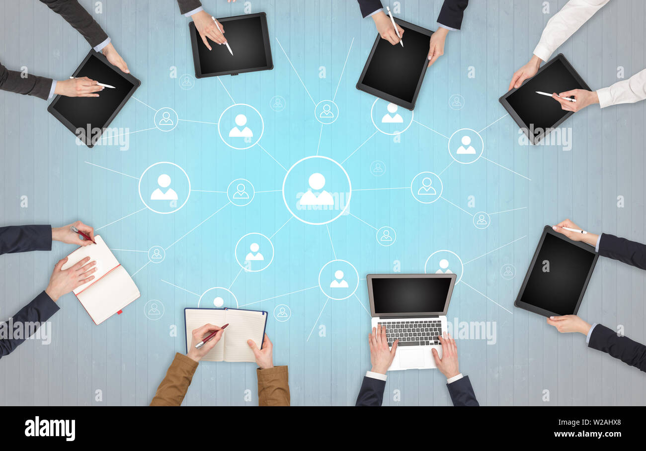 Group of people with devices in hands working in team on tablets ...