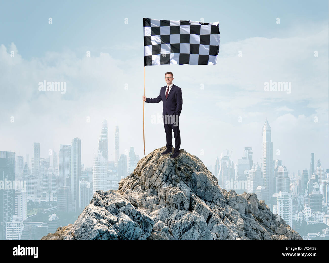 Successful businessman on the top of a city holding goal flag Stock ...