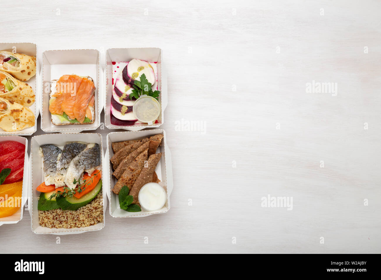 Set of healthy meals for the day in lunch boxes stands on a white table ...