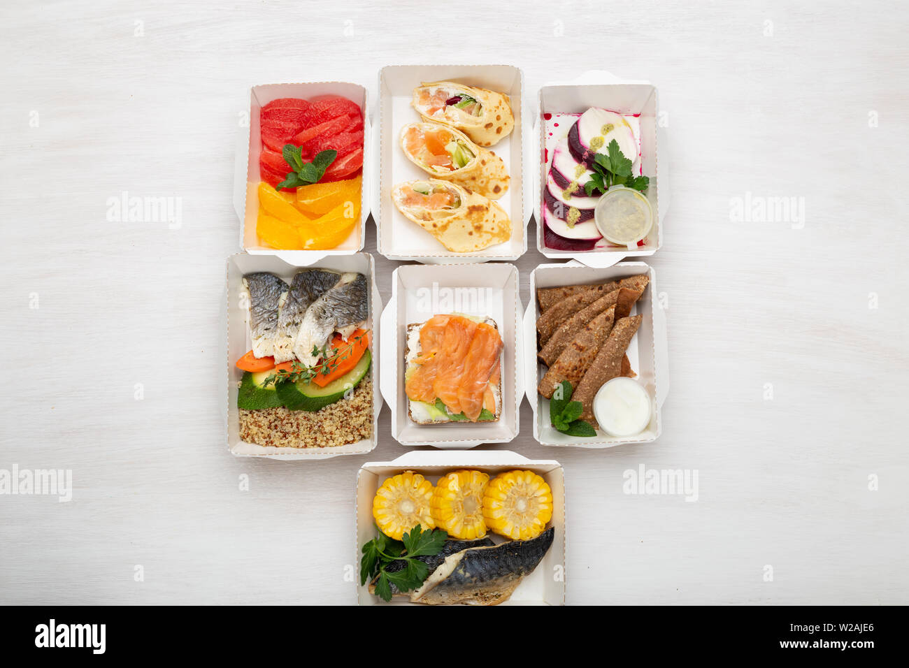 Set of healthy meals for the day in lunch boxes stands on a white table ...