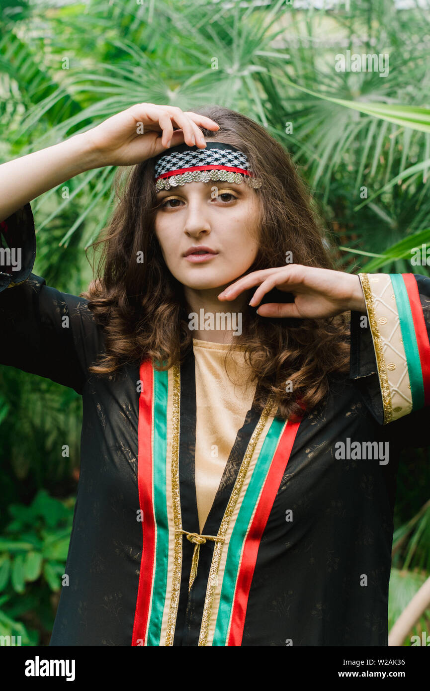 The girl from Jordan on the background of plants and palm leaves ...