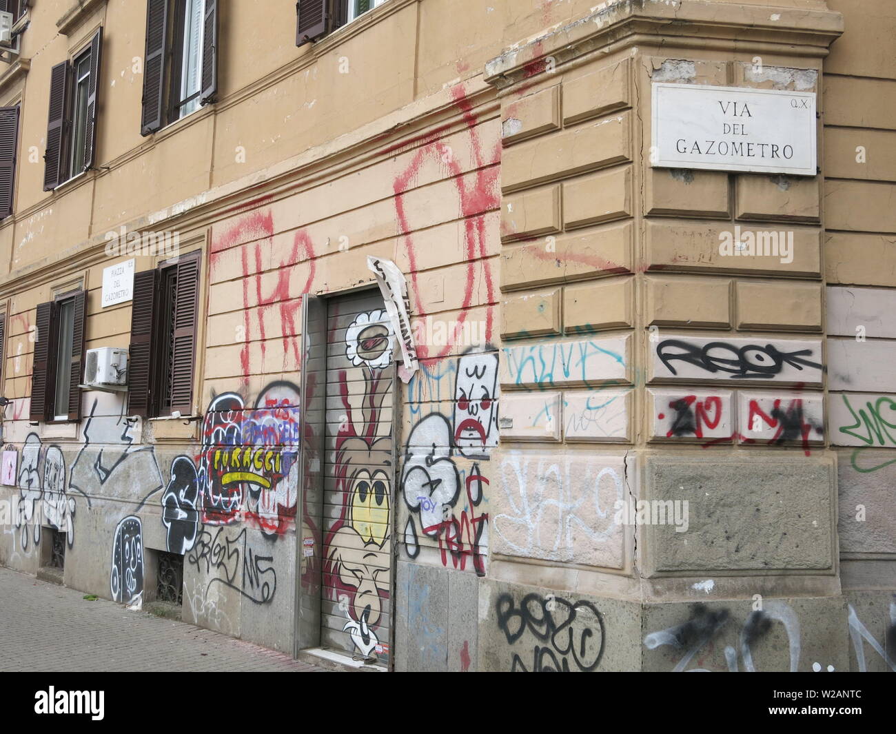 The building on the corner of Via del Gazometro is covered in graffiti ...