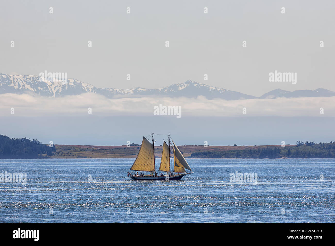 A vintage style two masted sailing ship out on the open waters in the ...