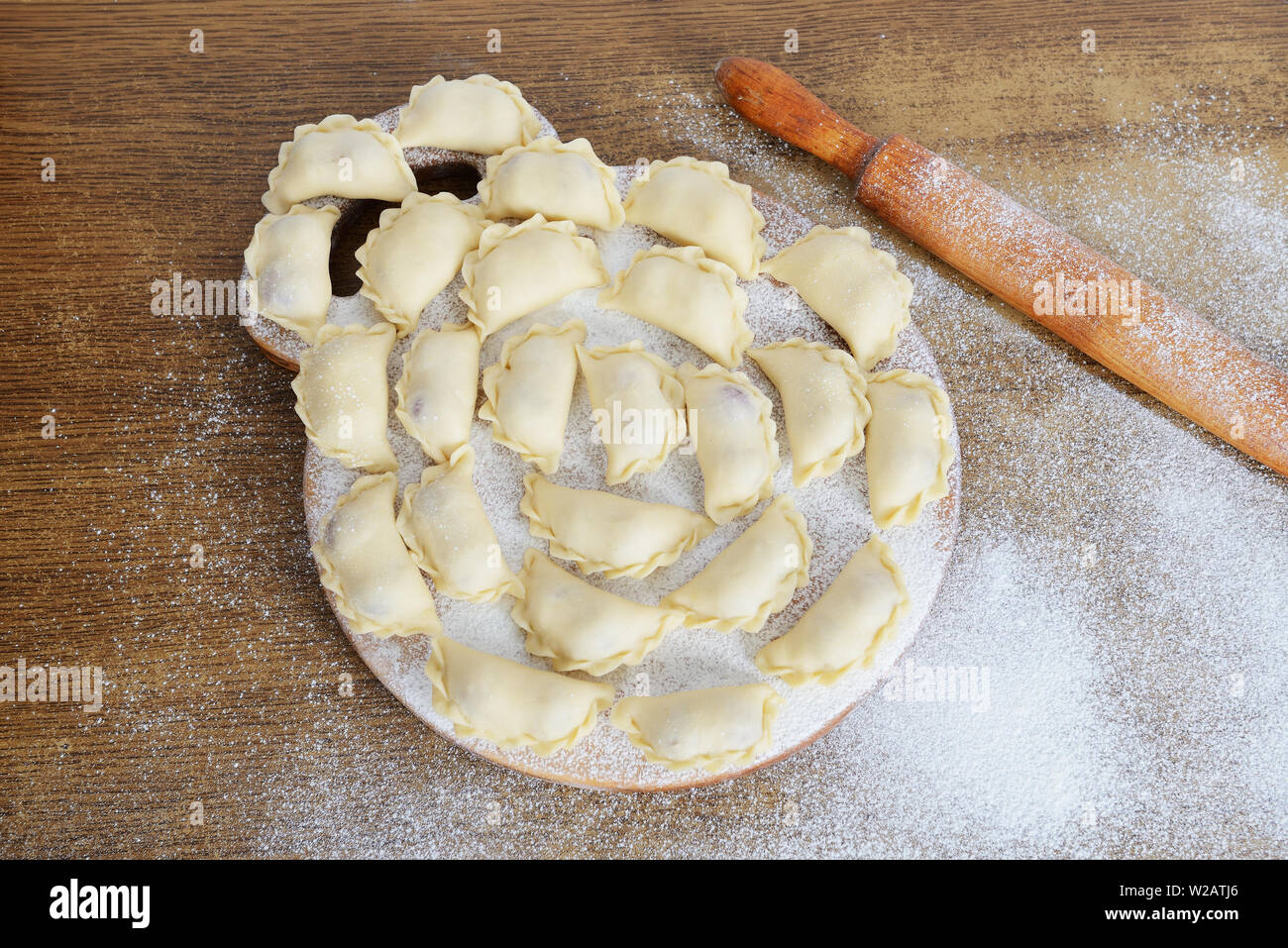 The raw traditional Ukrainian hand-made vareniki (dumpling) with cherry ...