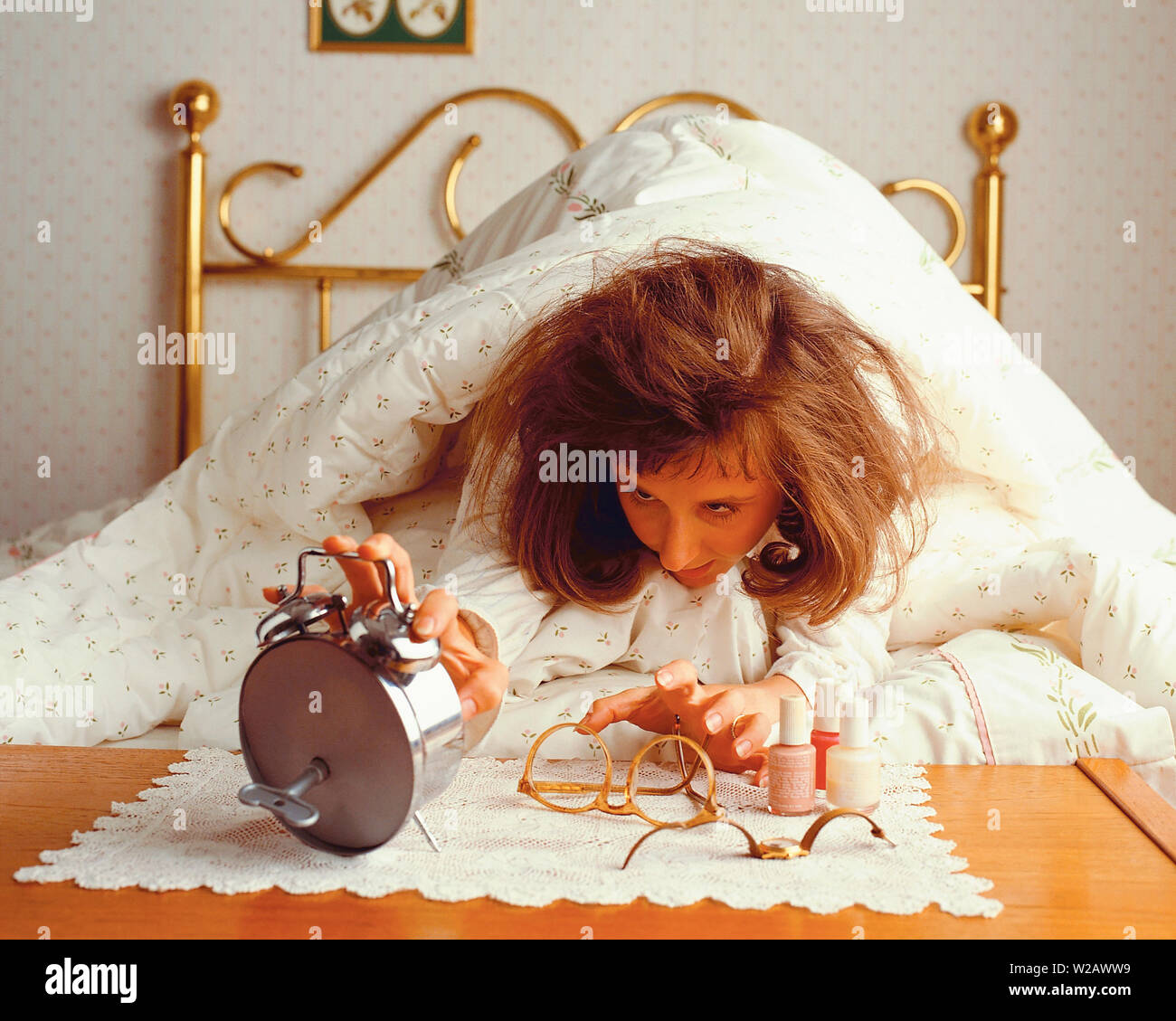 Woman waking up trying to use her alarm clock Stock Photo - Alamy