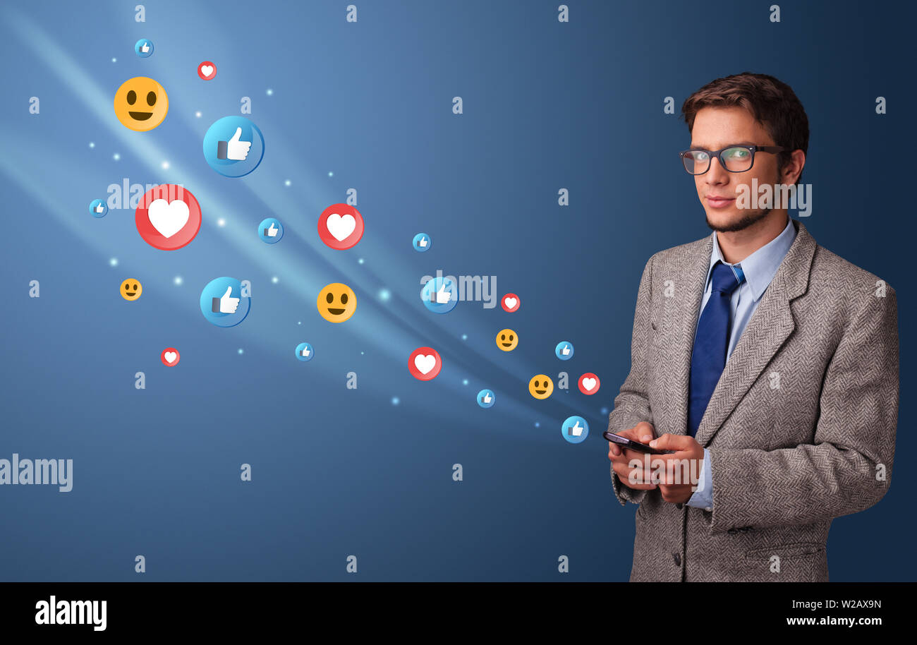 Young person using smartphone with flying social media icons around ...