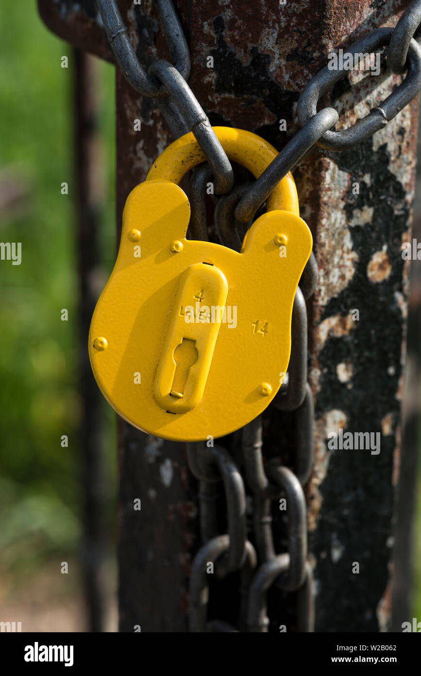 A heavy duty padlock securing a gate Stock Photo - Alamy