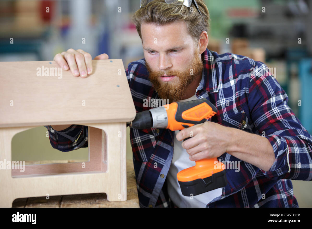 carpenter drilling wood using screw driver machine Stock Photo - Alamy
