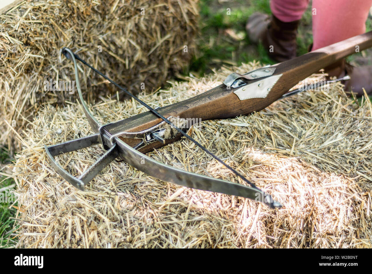 Medieval old crossbow without arrow exposed to a layer of hay at the ...