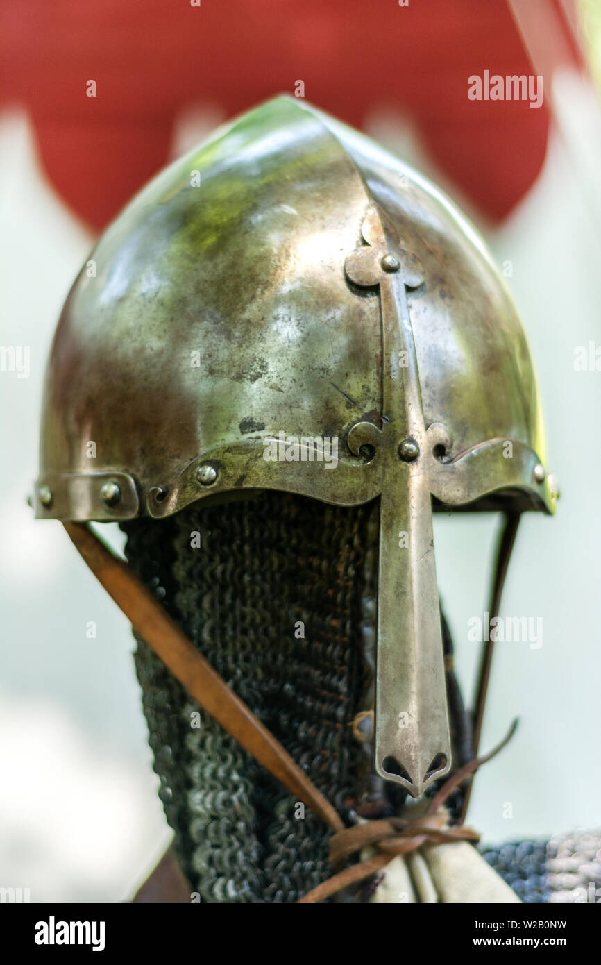 Medieval old metal helmet on the stand. Knightly armor and equipment ...