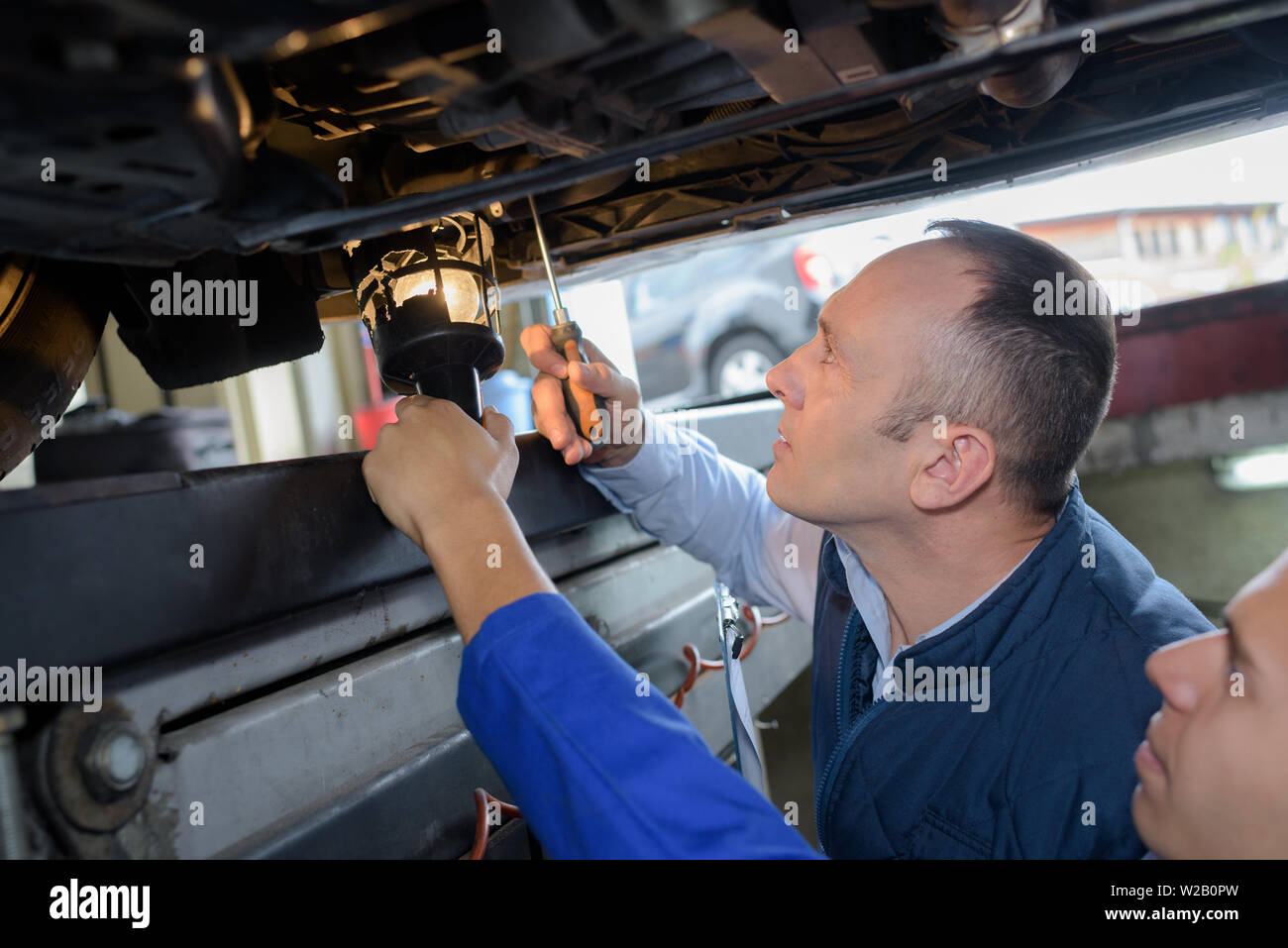 mechanic inspecting the vehicle Stock Photo - Alamy