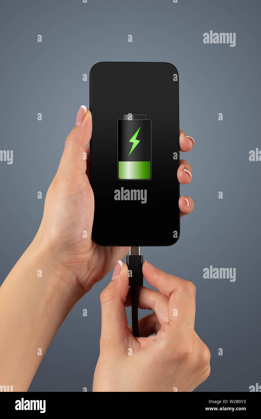 Elegant hand charging cellphone with low battery Stock Photo - Alamy