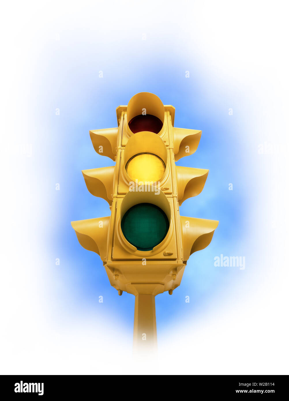Upward view of tall vintage yellow traffic signal with yellow light on ...