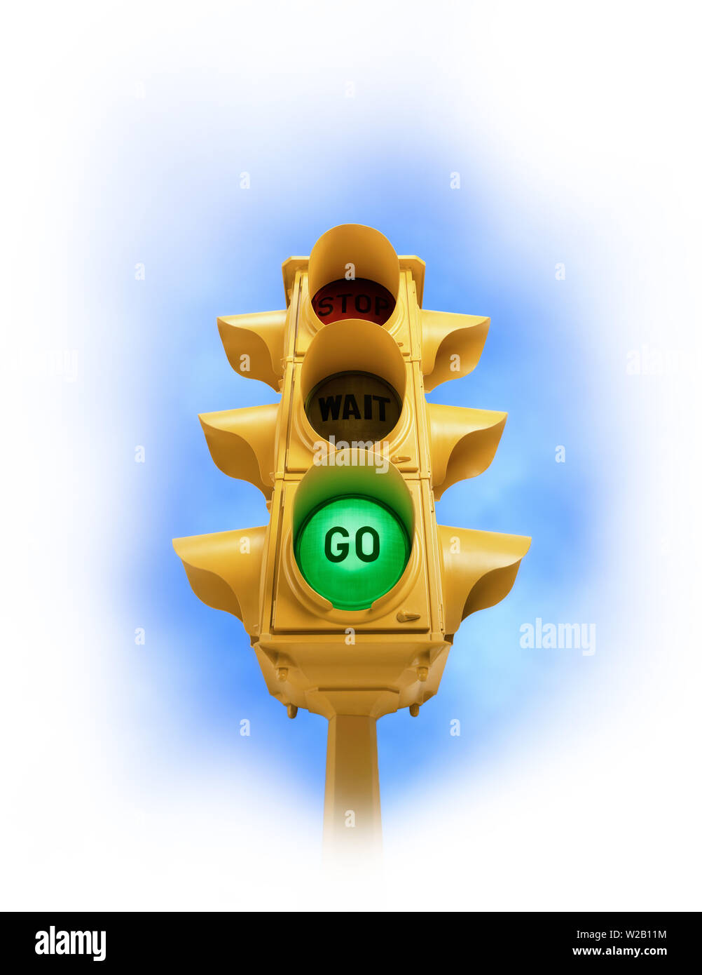 Upward view of tall vintage yellow traffic signal with green GO light ...