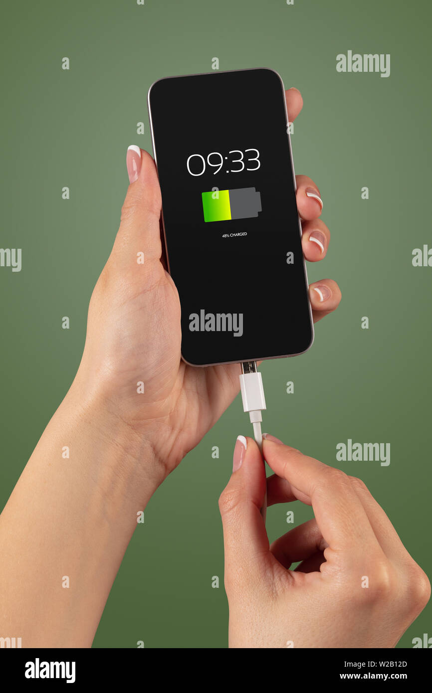 Elegant hand charging smartphone with low battery Stock Photo - Alamy
