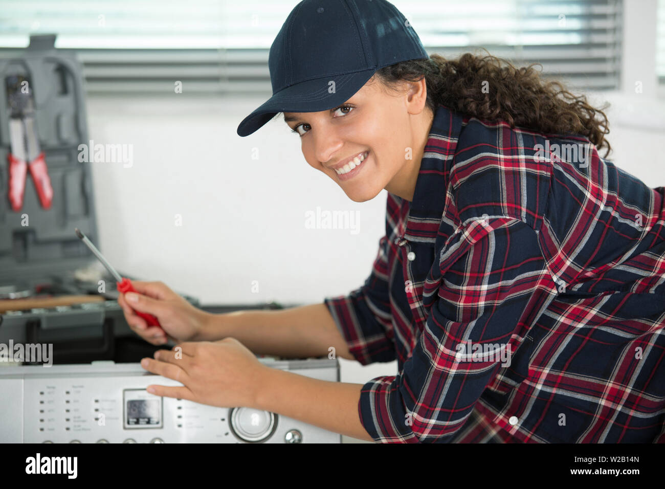 young woman fixing a machine Stock Photo - Alamy