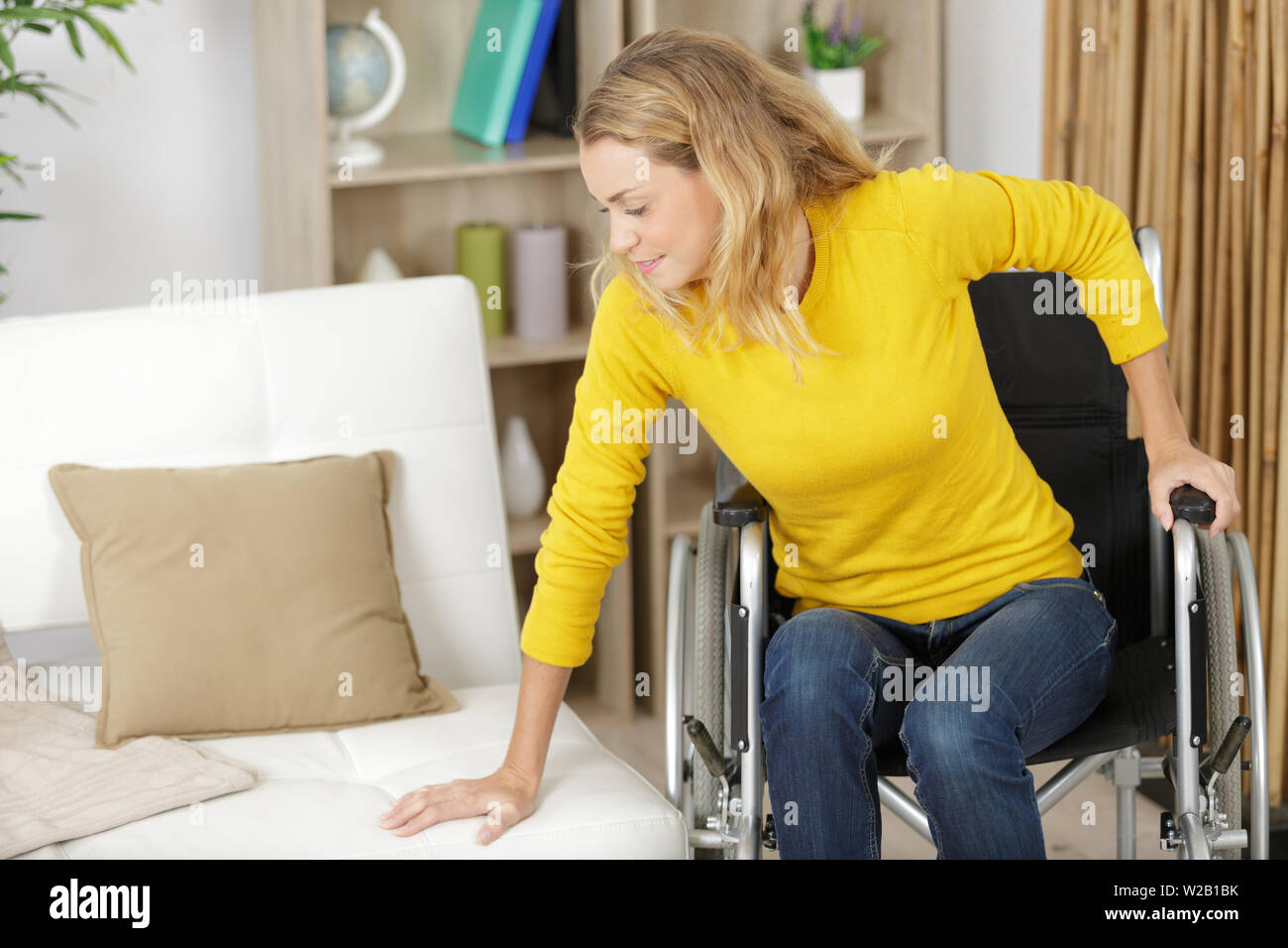 woman moving from wheelchair to sofa Stock Photo - Alamy