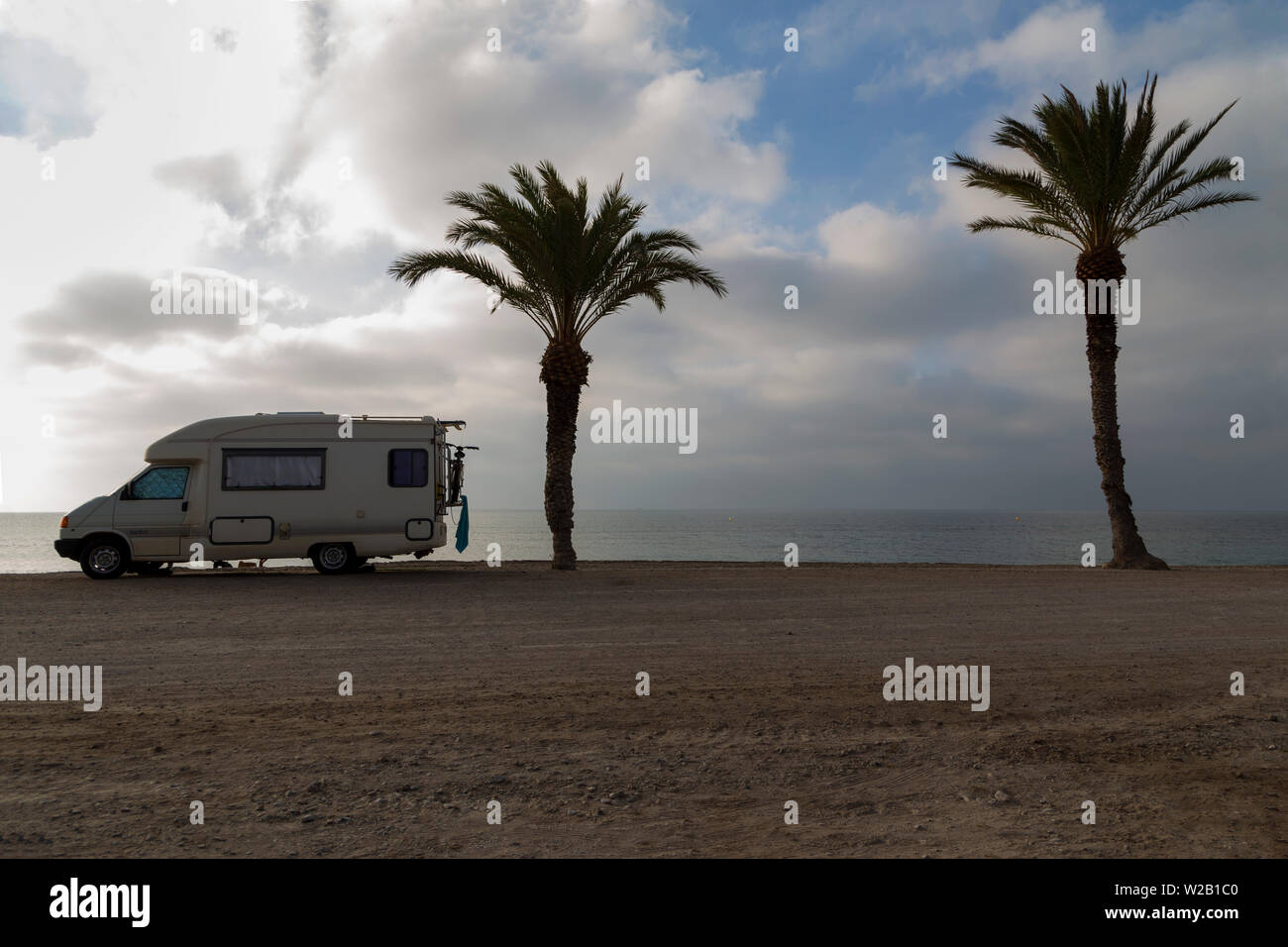 One mobile caravan on a beach with palm trees dark cloudy morning Stock ...