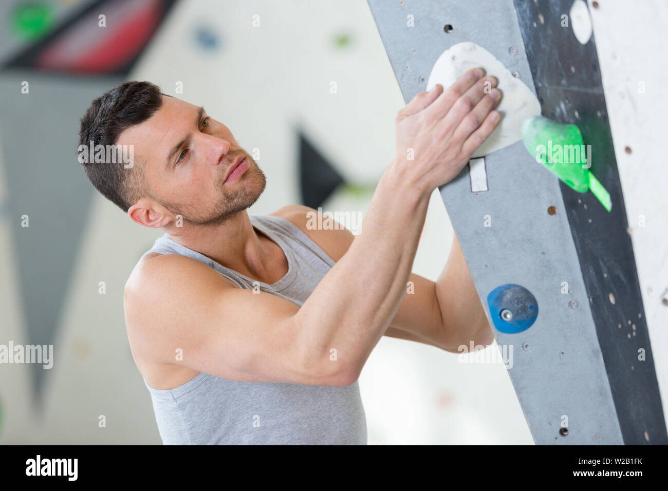 manwith hand on climbing wall grip Stock Photo - Alamy