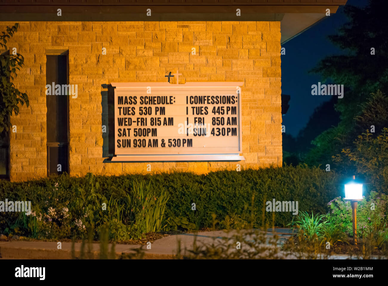 Catholic church mass and confessions schedule illuminated at night in ...