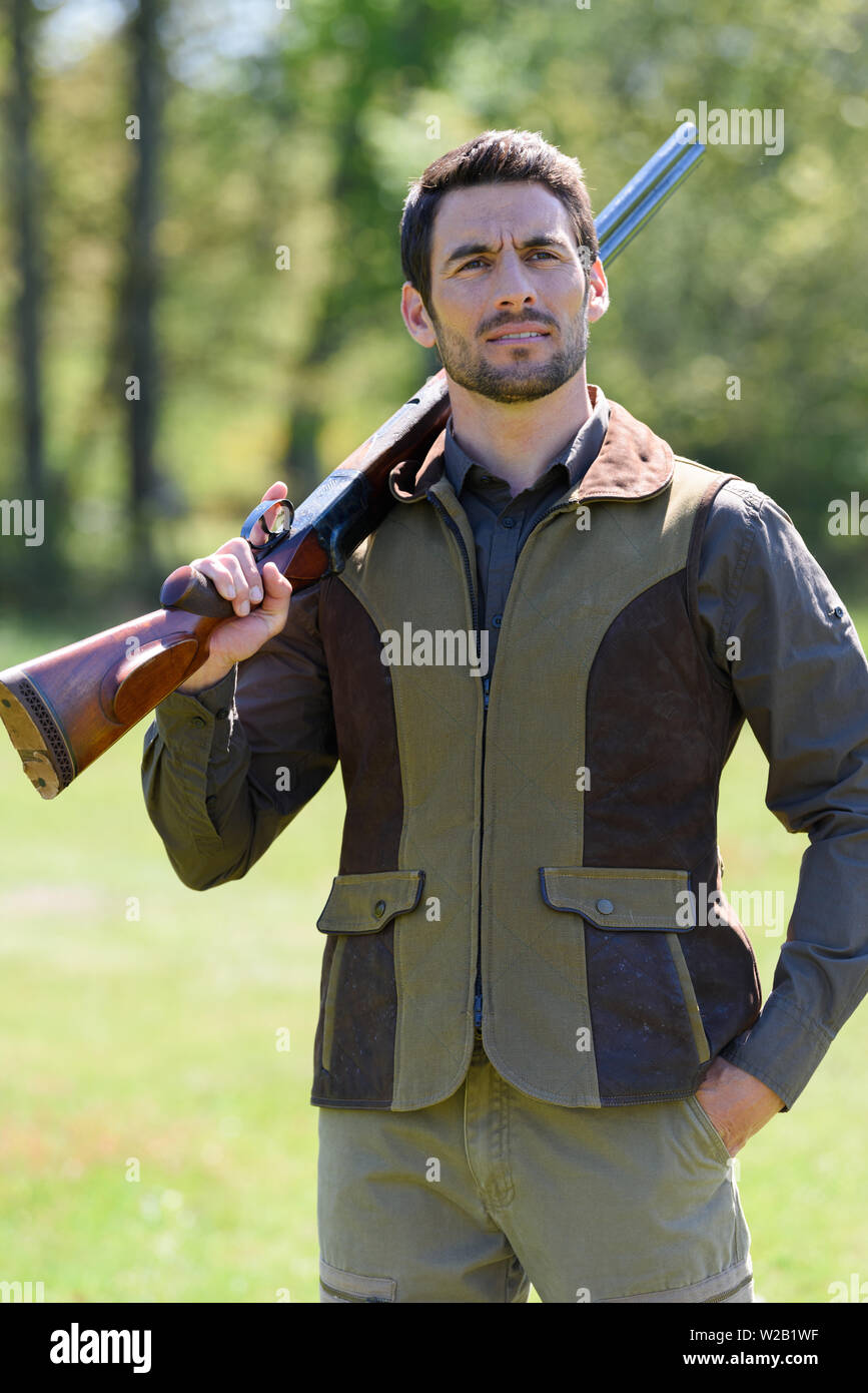 male farmer carrying a rifle walks along Stock Photo - Alamy