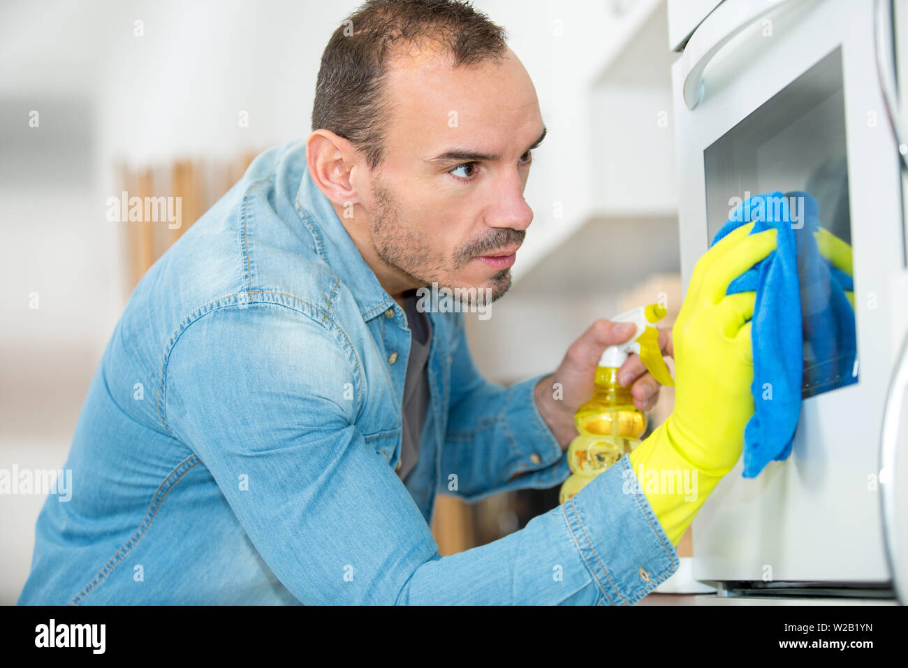 man cleans oven Stock Photo - Alamy