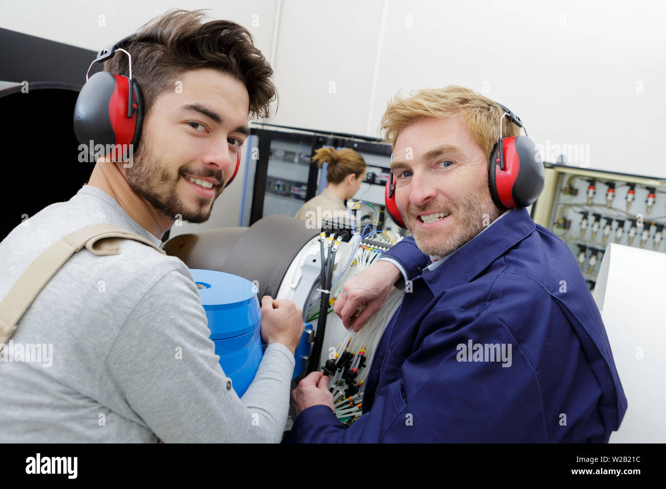 two men in workwear in a workshop Stock Photo - Alamy