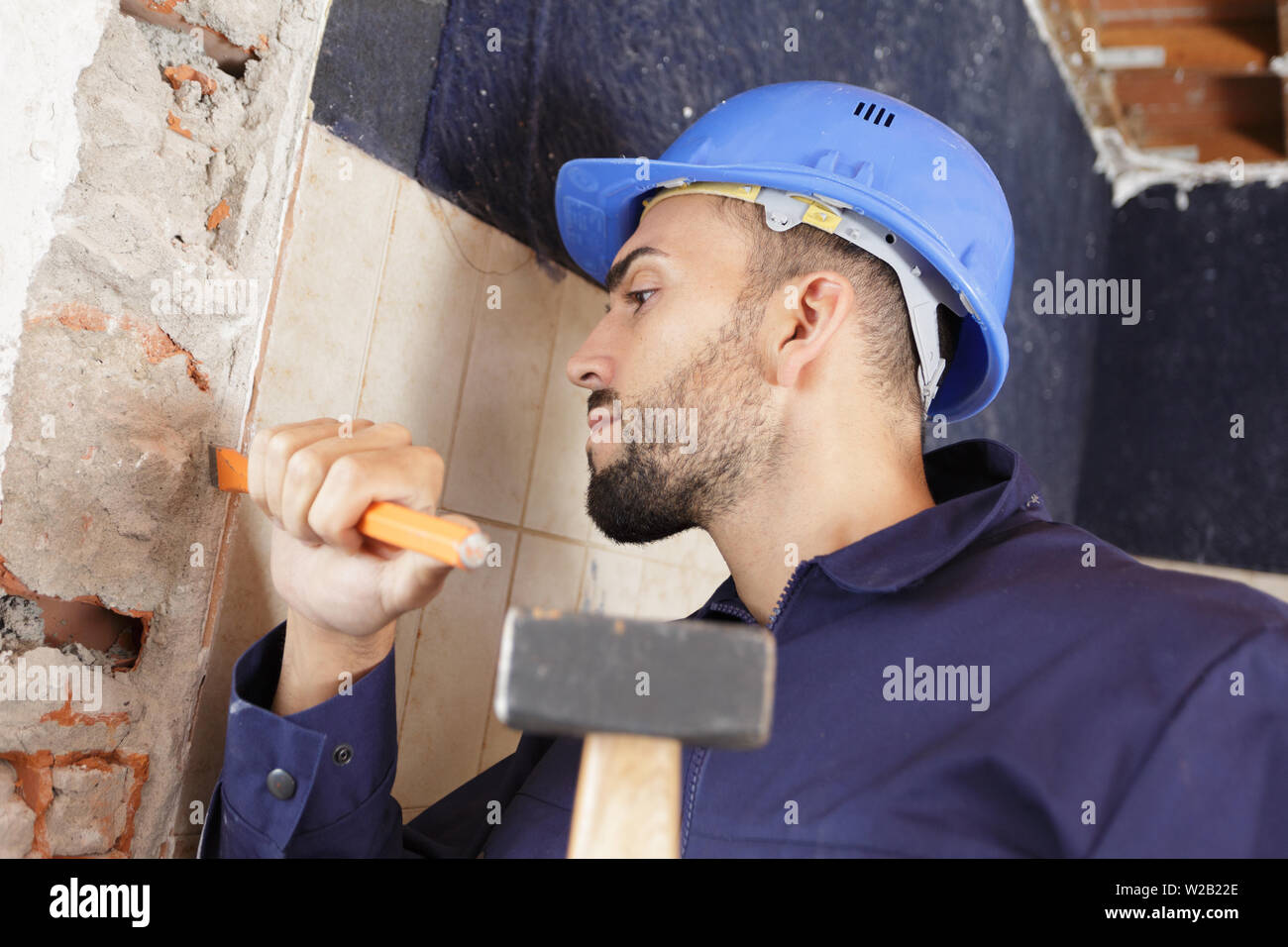 man wearing with a hammer on wall Stock Photo - Alamy