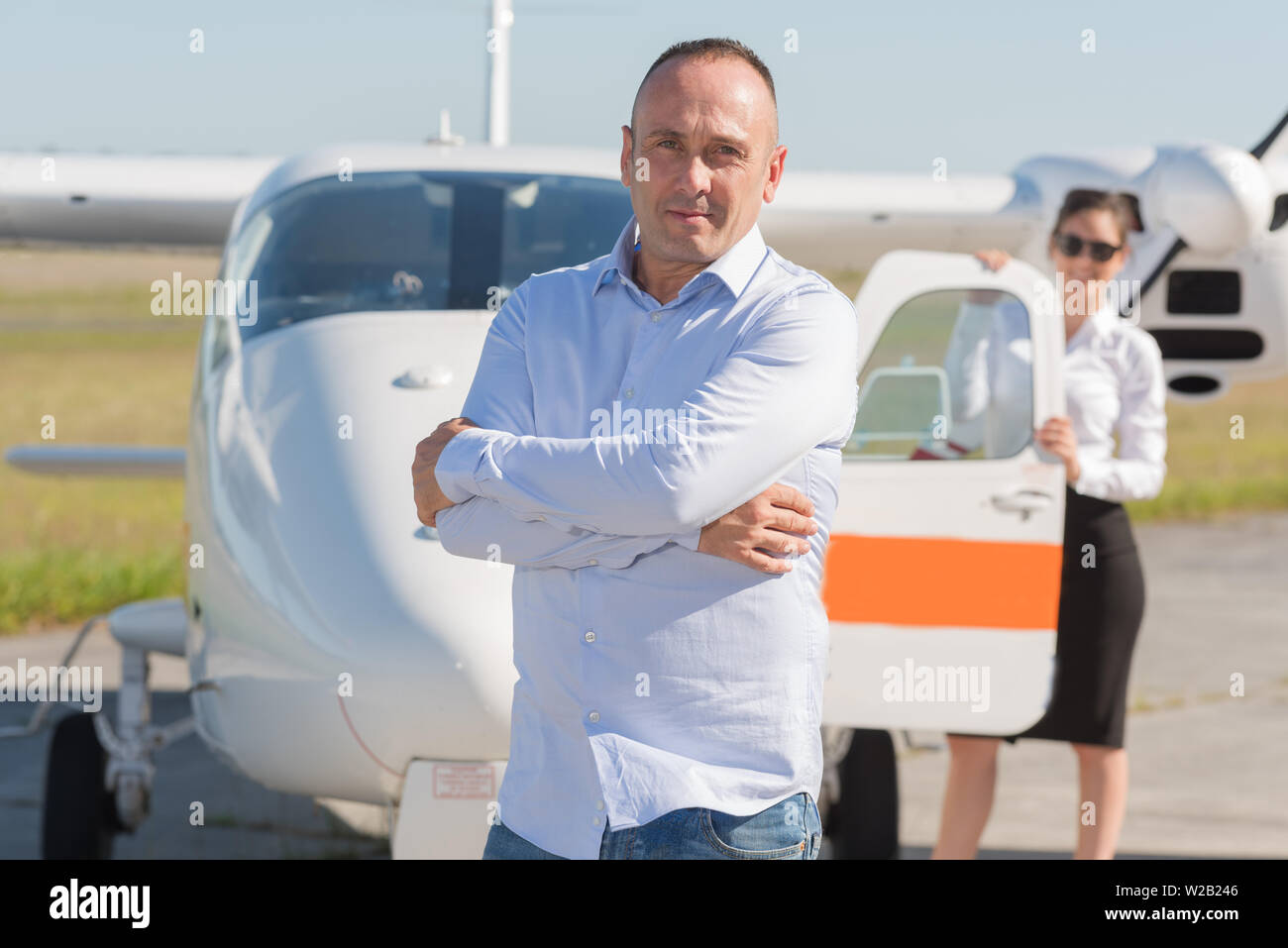 man looking at camera next to his private airplane Stock Photo - Alamy