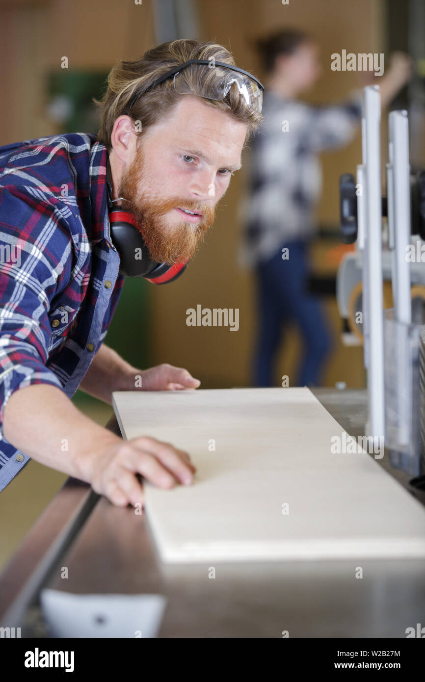carpenter is cutting wood with machine Stock Photo - Alamy