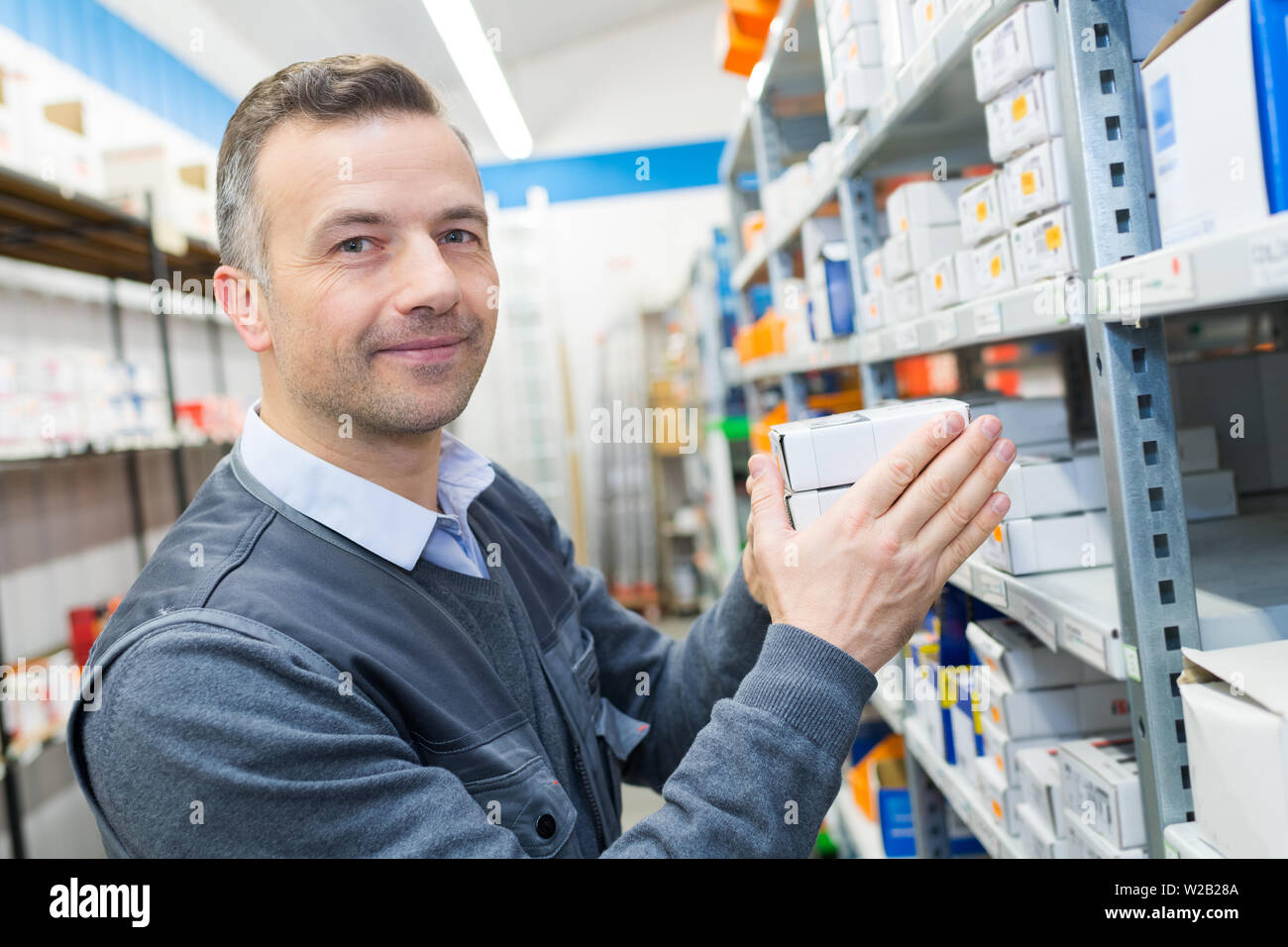 man tidying goods in a warehouse Stock Photo - Alamy