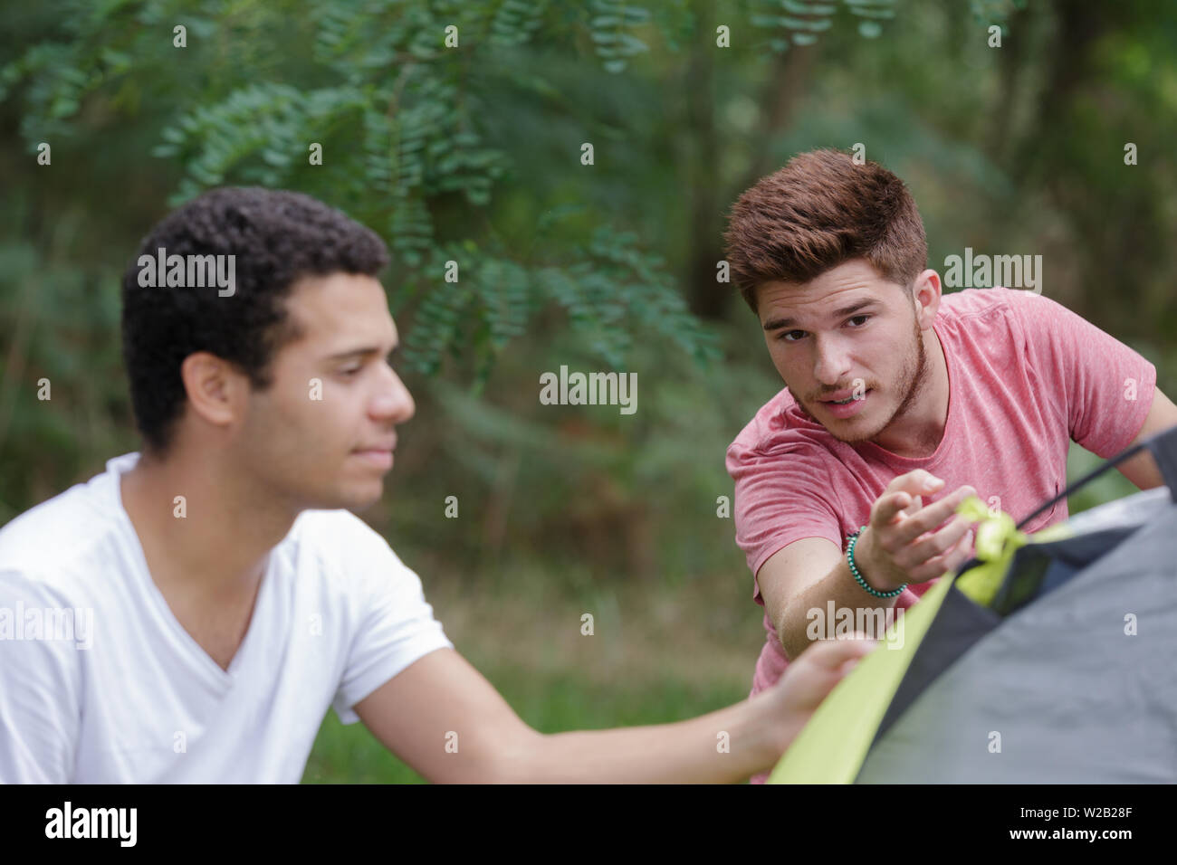 two men fixing a tent Stock Photo - Alamy