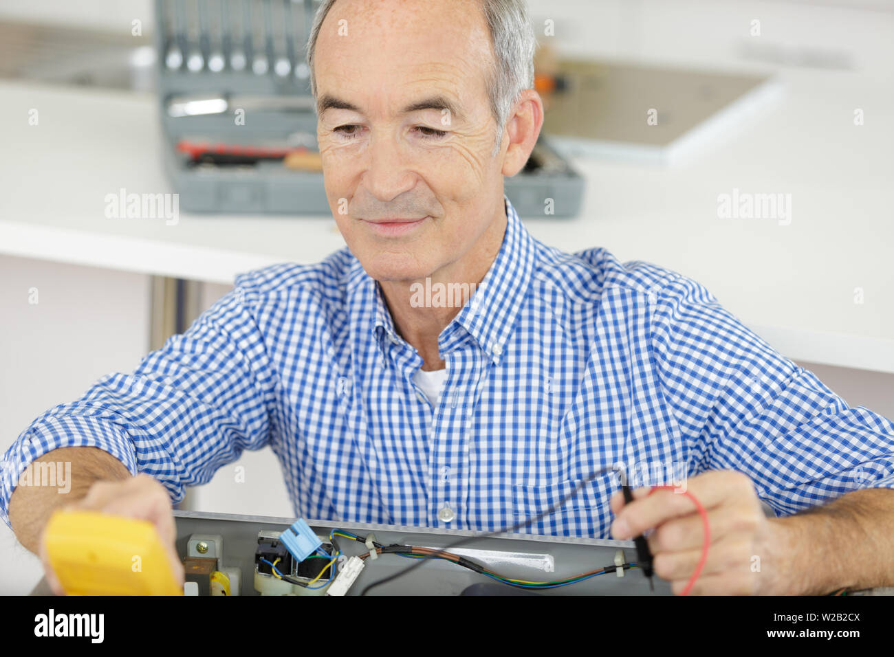 senior man testing appliance with multimeter Stock Photo - Alamy