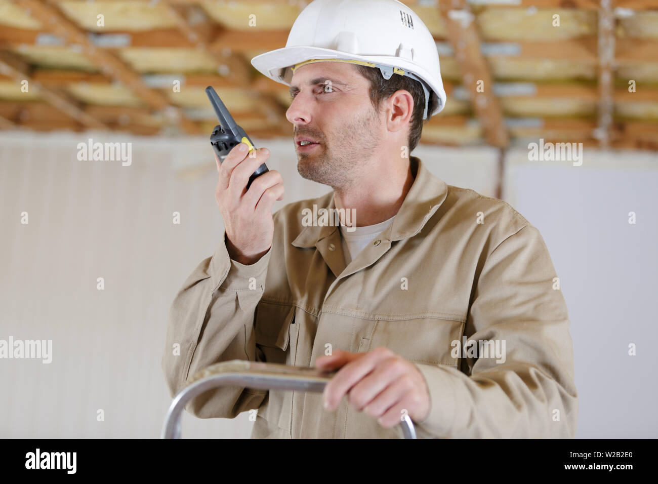 builder talking on portable uhf radio transceiver Stock Photo - Alamy
