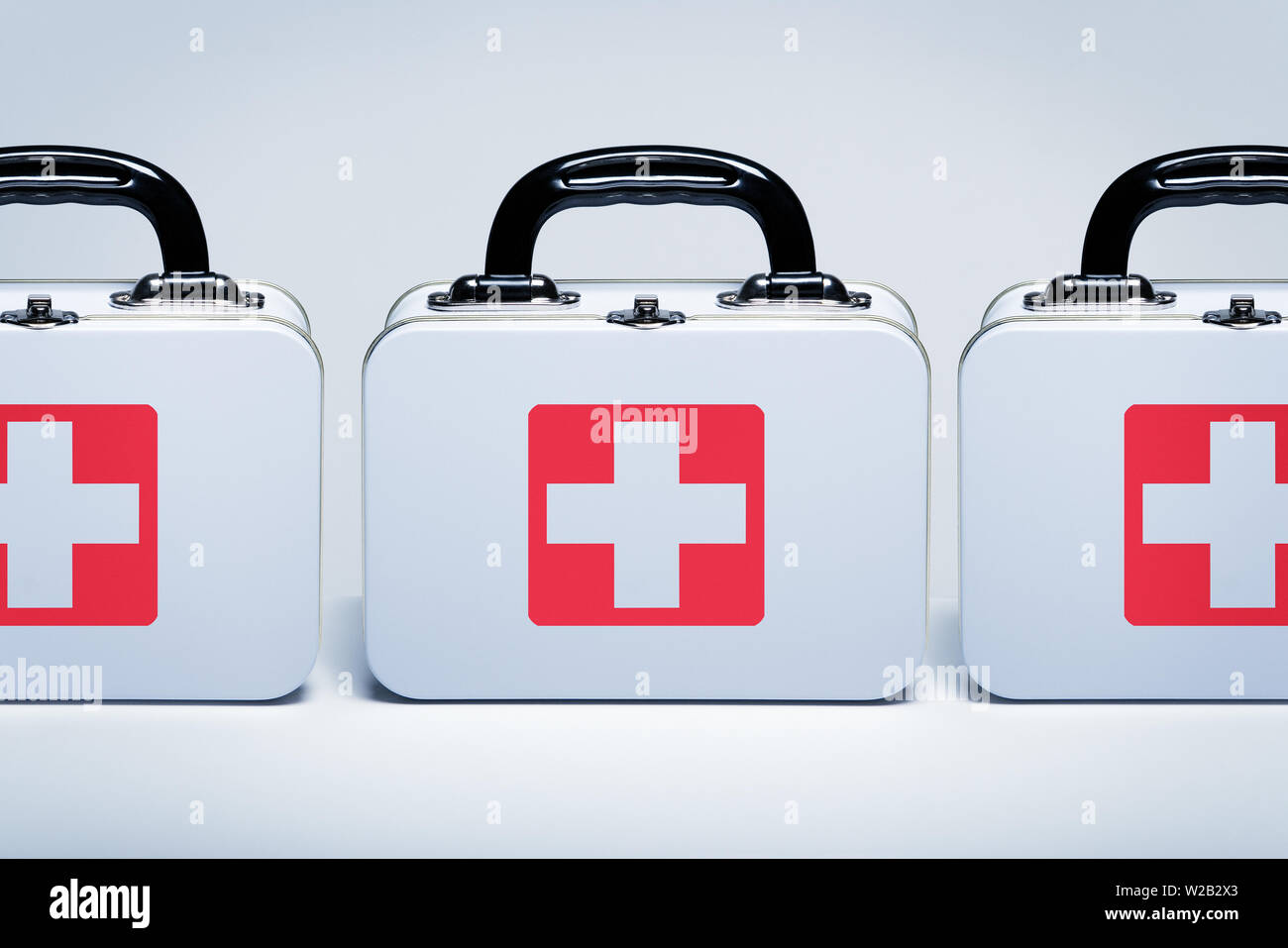 First aid kits with cross emblems in a row on light grey background ...
