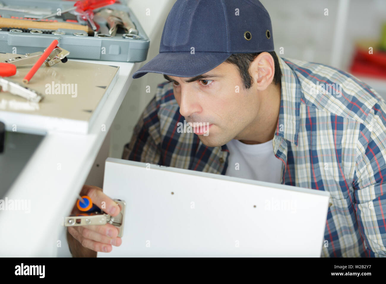 man during installation of a kitchen furniture Stock Photo - Alamy