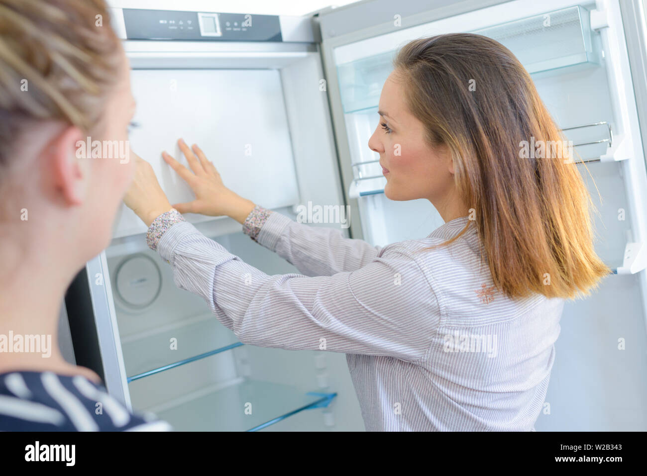 shop assistant helps woman Stock Photo - Alamy
