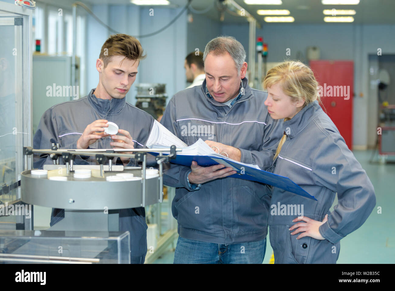 engineers in mechanical factory reading instructions Stock Photo - Alamy