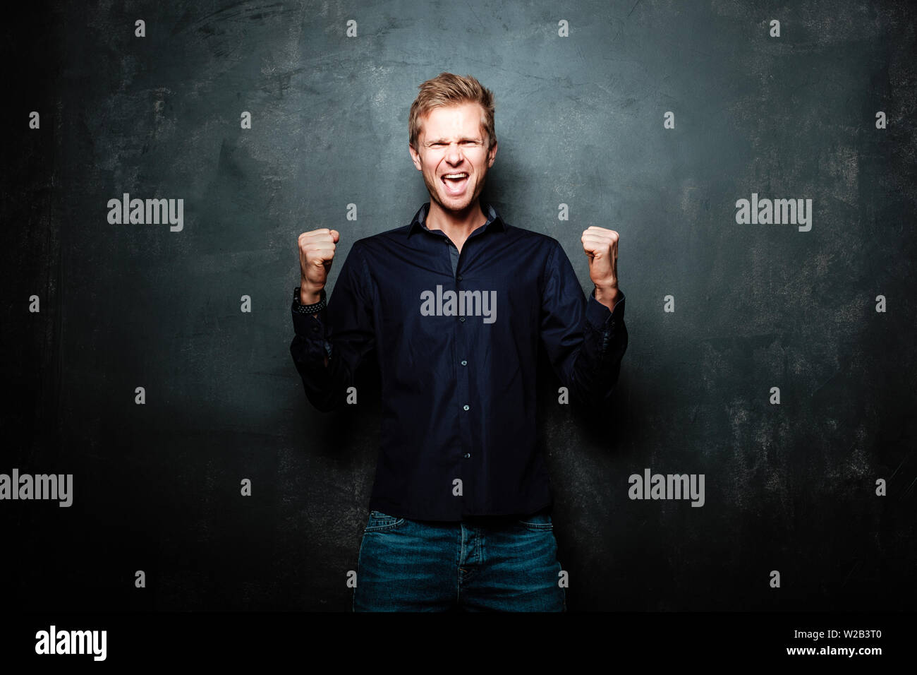 A young man shout out loud on black background Stock Photo - Alamy