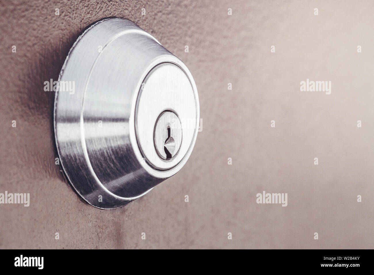 Modern new metallic grey shiny keyhole on door background. Side view of ...