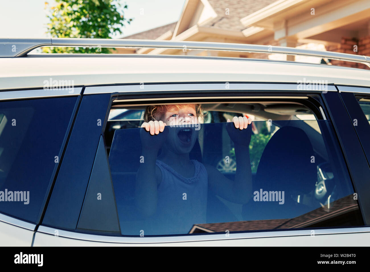 Preschooler little Caucasian girl left alone in car during hot sunny ...