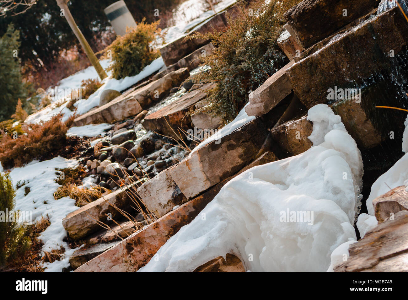 Stone covered with snow as water trickles down the falls Stock Photo ...
