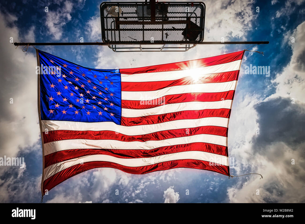 American flag with the sun shining behind it hi-res stock photography ...
