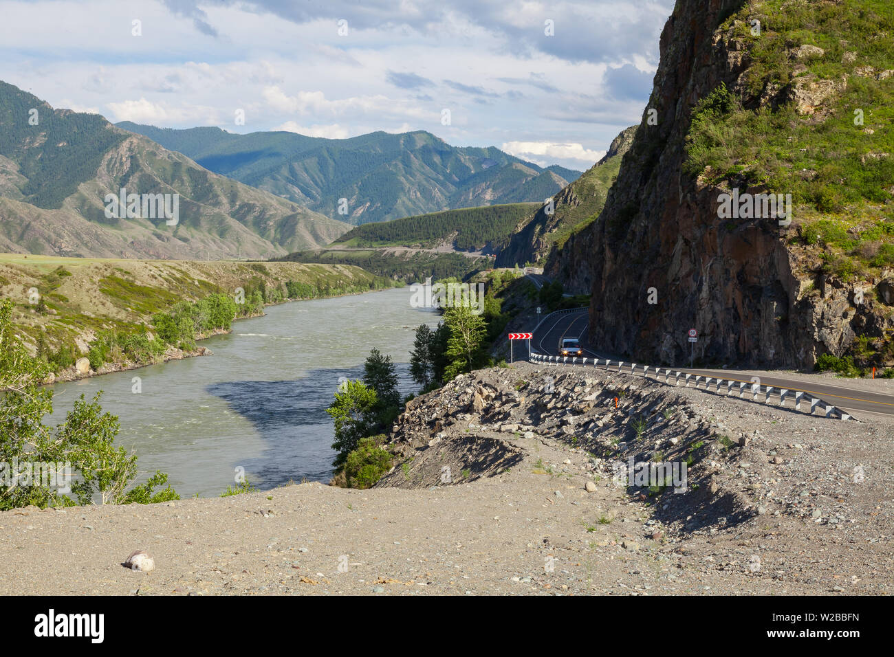 A new winding asphalt black road with a yellow dividing strip between ...