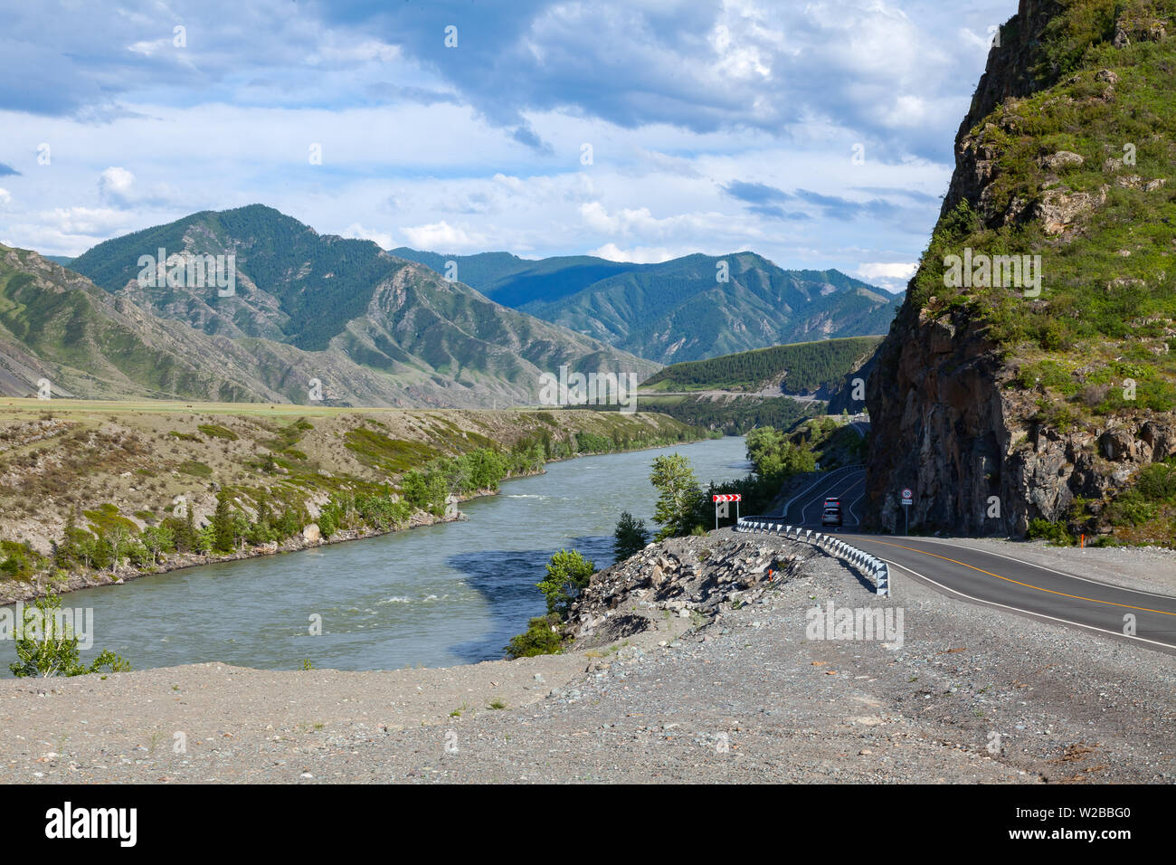 A new winding asphalt black road with a yellow dividing strip between ...