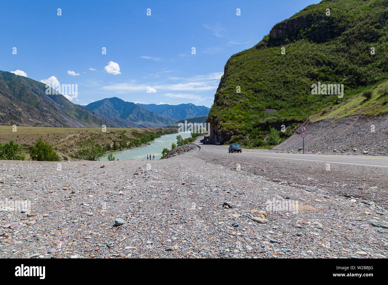 A new winding asphalt black road with a yellow dividing strip between ...